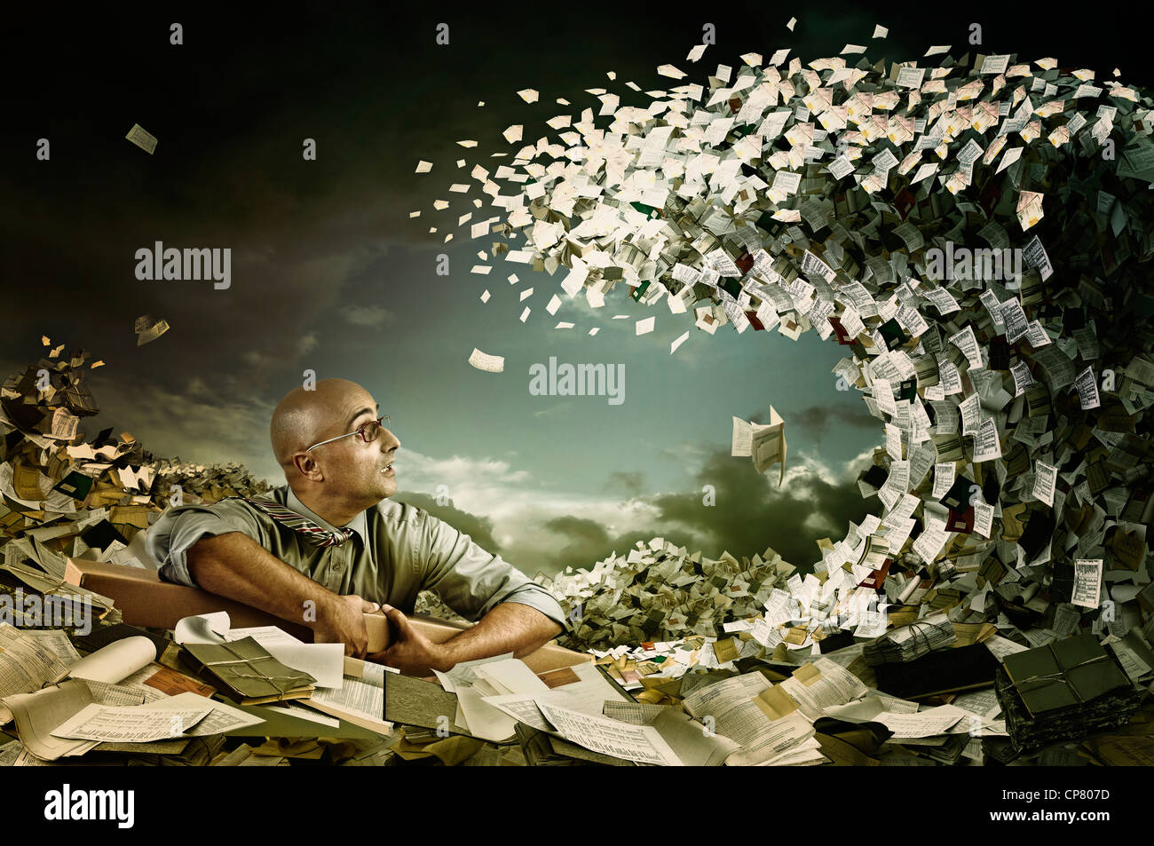 Castaway businessman in a sea of papers and files Stock Photo - Alamy