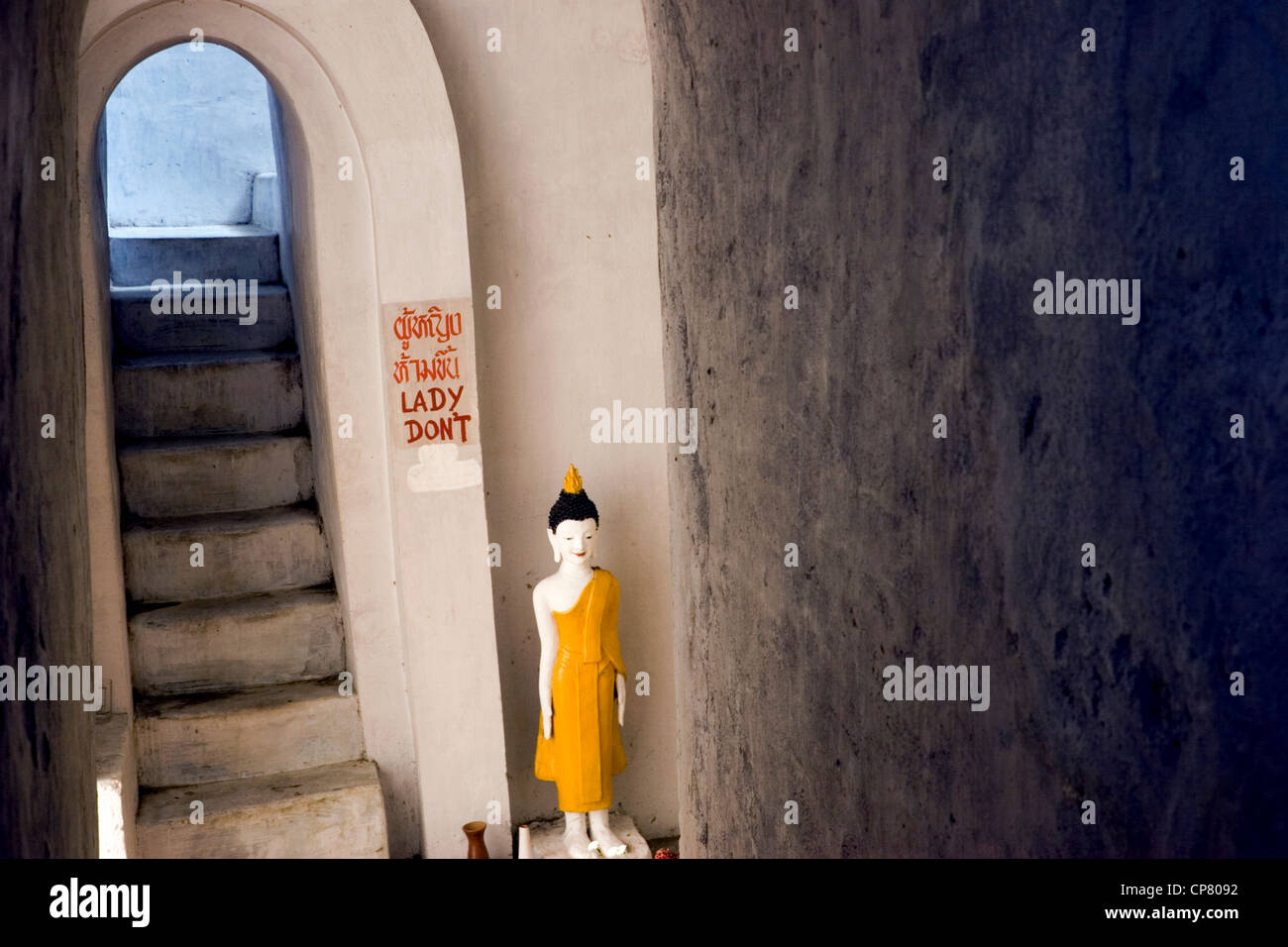 A sign on a wall near a statue tells women they are not allowed ...