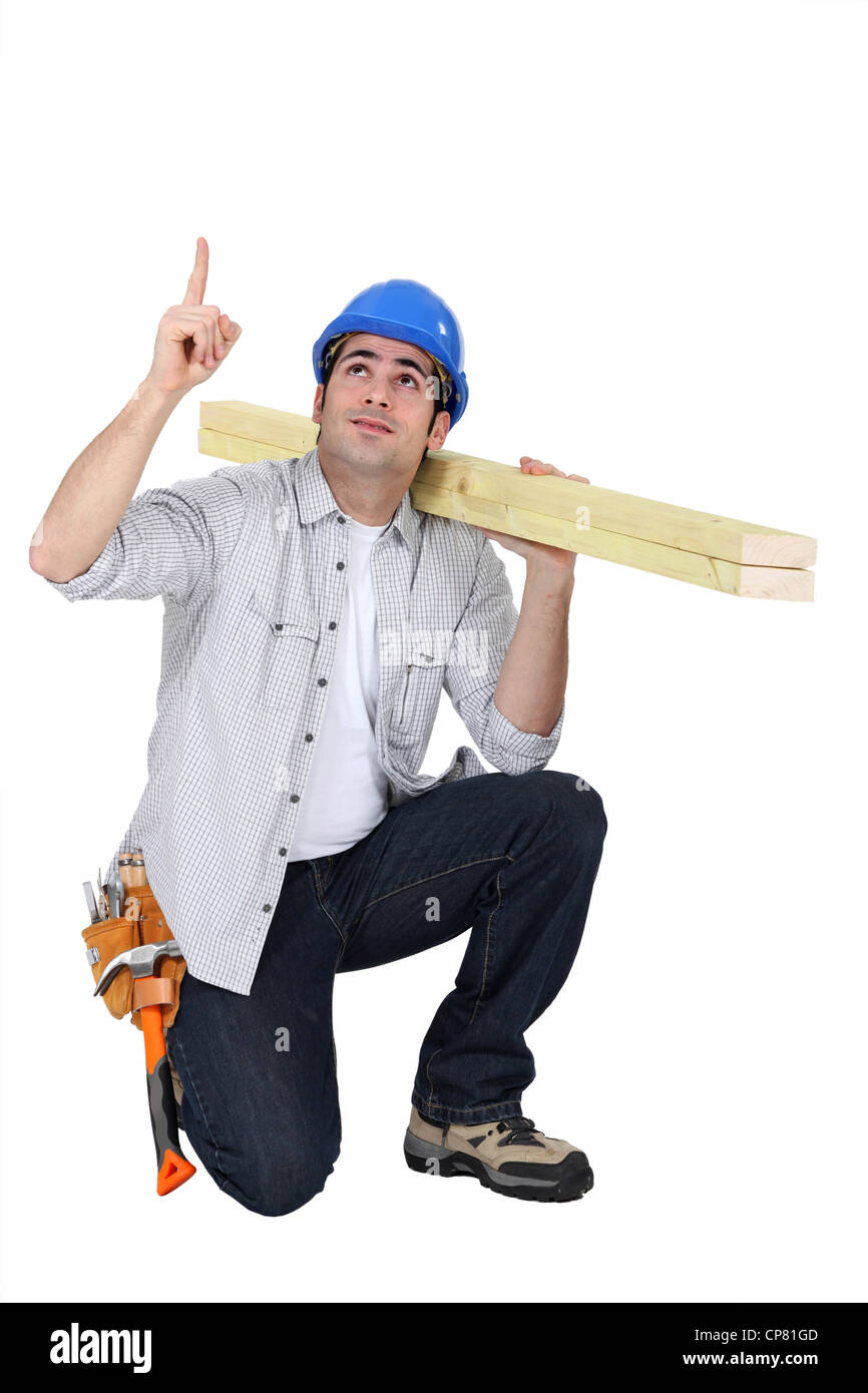 Carpenter kneeling and pointing upwards Stock Photo - Alamy