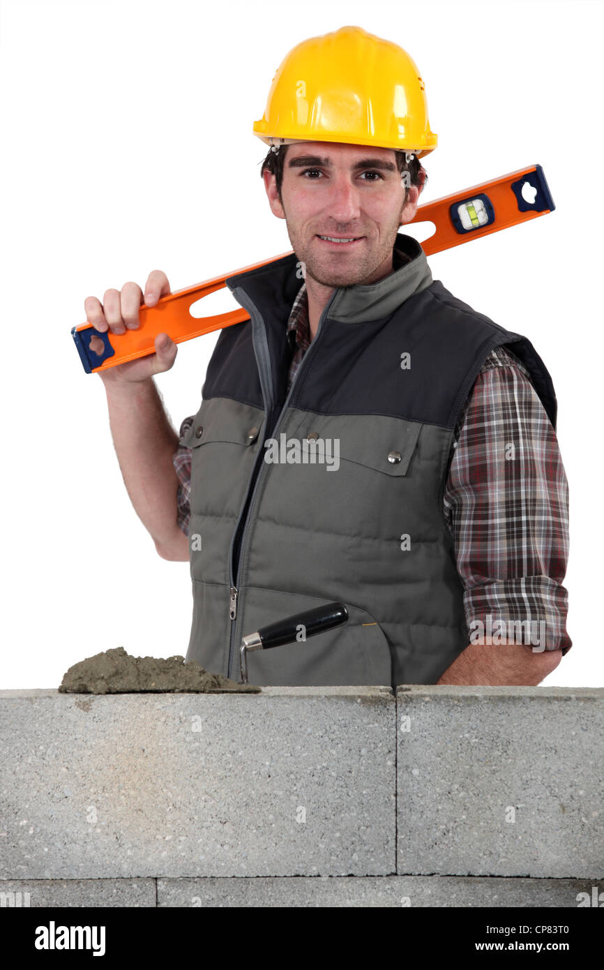 Stonemason standing before a wall and carrying a spirit level Stock ...