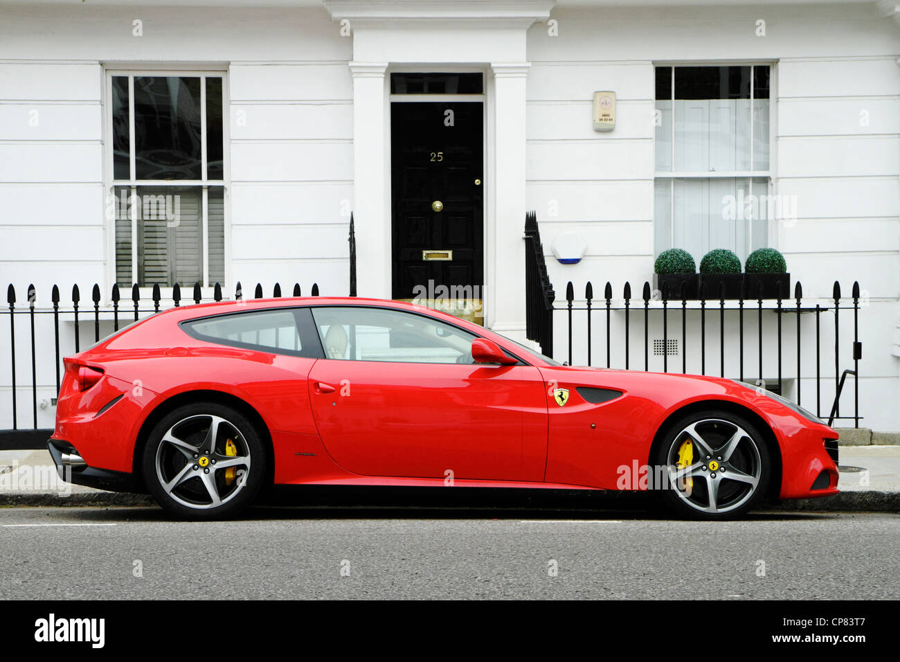 Red Ferrari FF sports car parked in affluent street, London borough of ...
