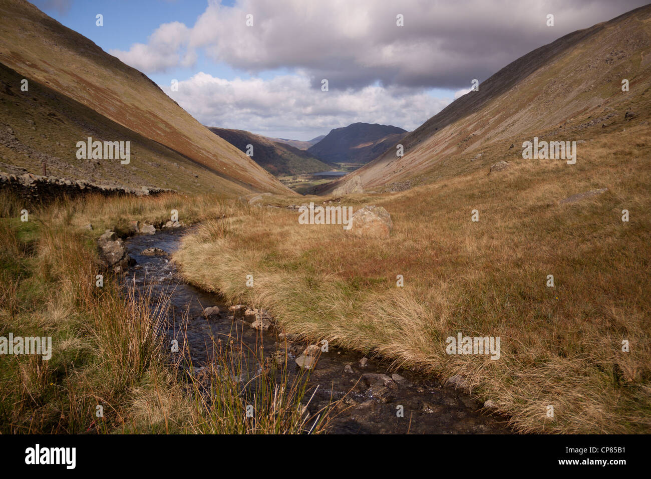 winding stream in mountain pass with distant mountains and sky Stock ...