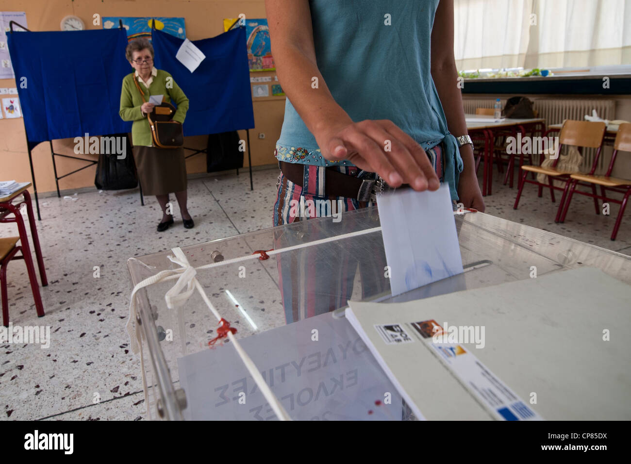 Athens.Greece,6/5/2012 A young woman casting her vote while an older ...