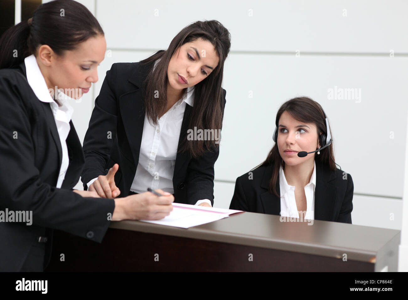 Businesswomen filling in paperwork Stock Photo - Alamy