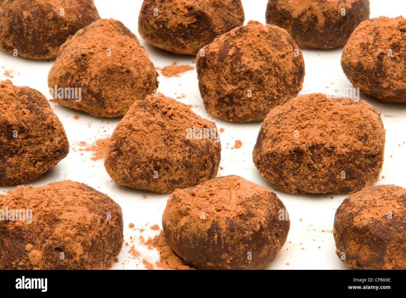 Bunch of chocolate truffles with cocoa powder on a white surface Stock ...