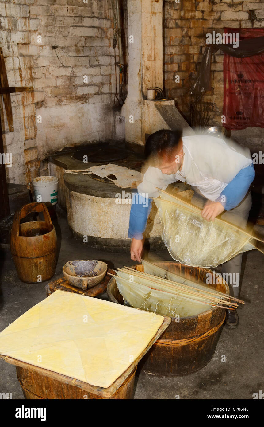 Chinese worker making tofu from bean curds in a shop in ancient ...