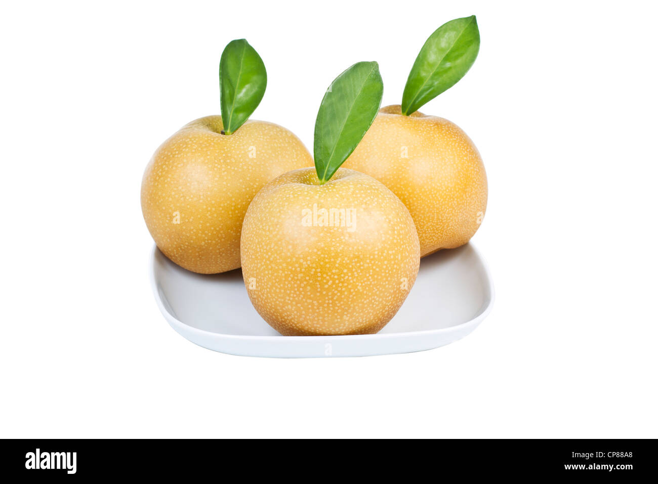 Three large apple pears with green leaves in single plate on white ...