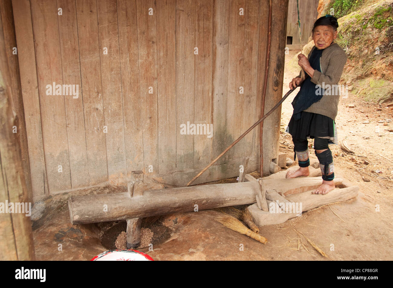 Old Basha Miao woman using a foot grindstone Stock Photo - Alamy