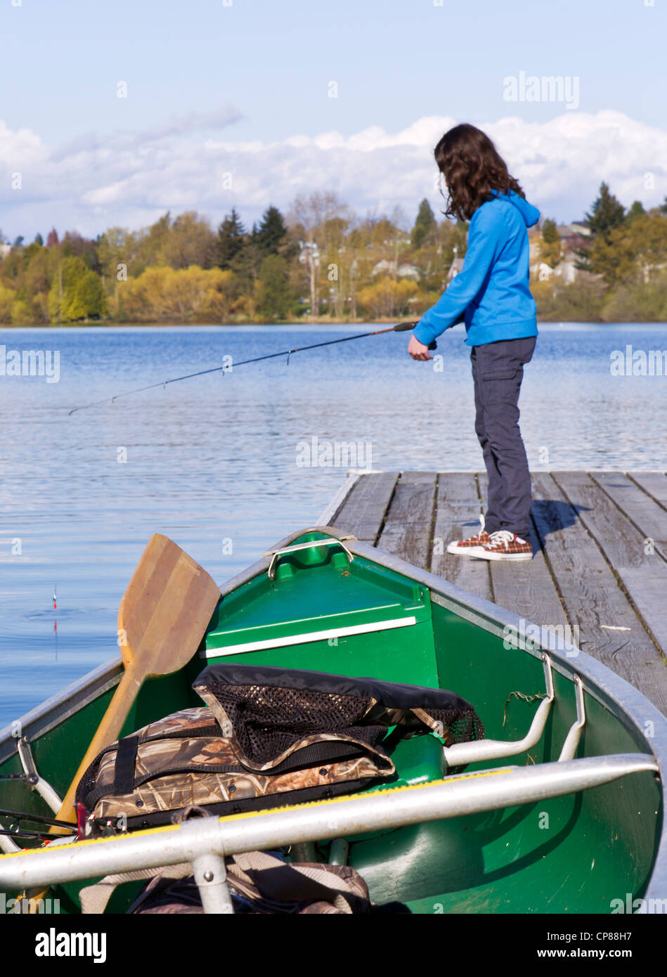 Fishing boat on dock with young girl fishing in background Stock Photo ...