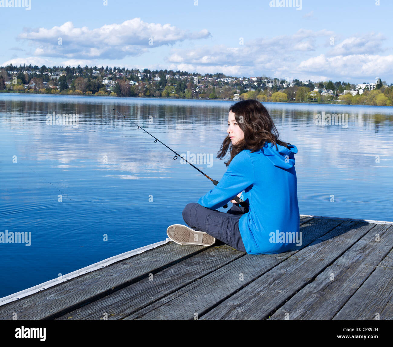 Young girl waiting for a fish to bite in Lake Washington during sunny ...
