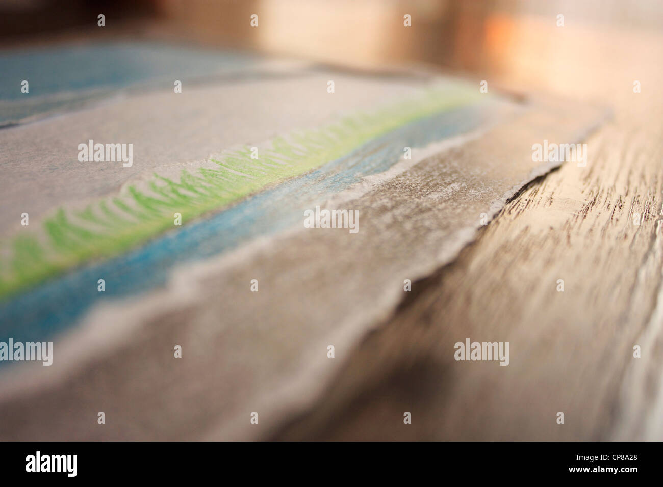Close up detail of a crayon drawing on pieces of paper. The hand torn ...