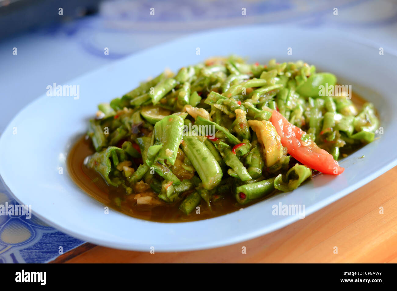 String bean spicy salad on blue dish Stock Photo - Alamy