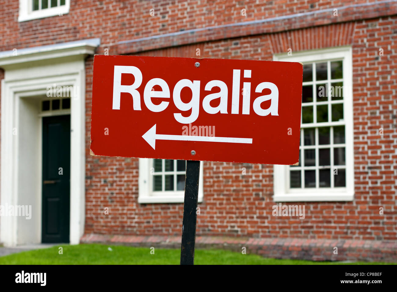 Red sign shows graduates where to pick up their graduation ceremony cap ...