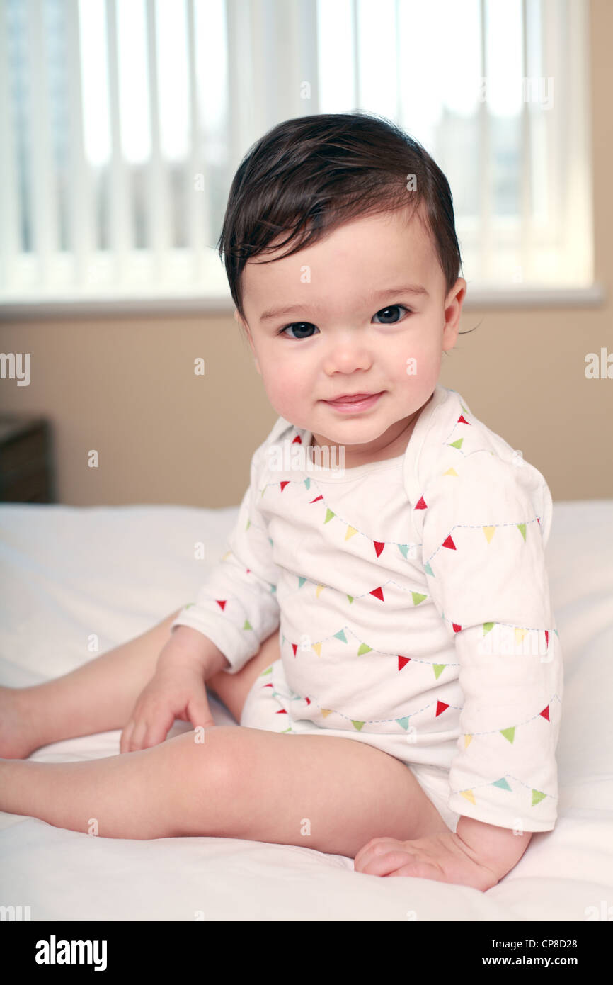 Gorgeous baby sat on bed Stock Photo - Alamy