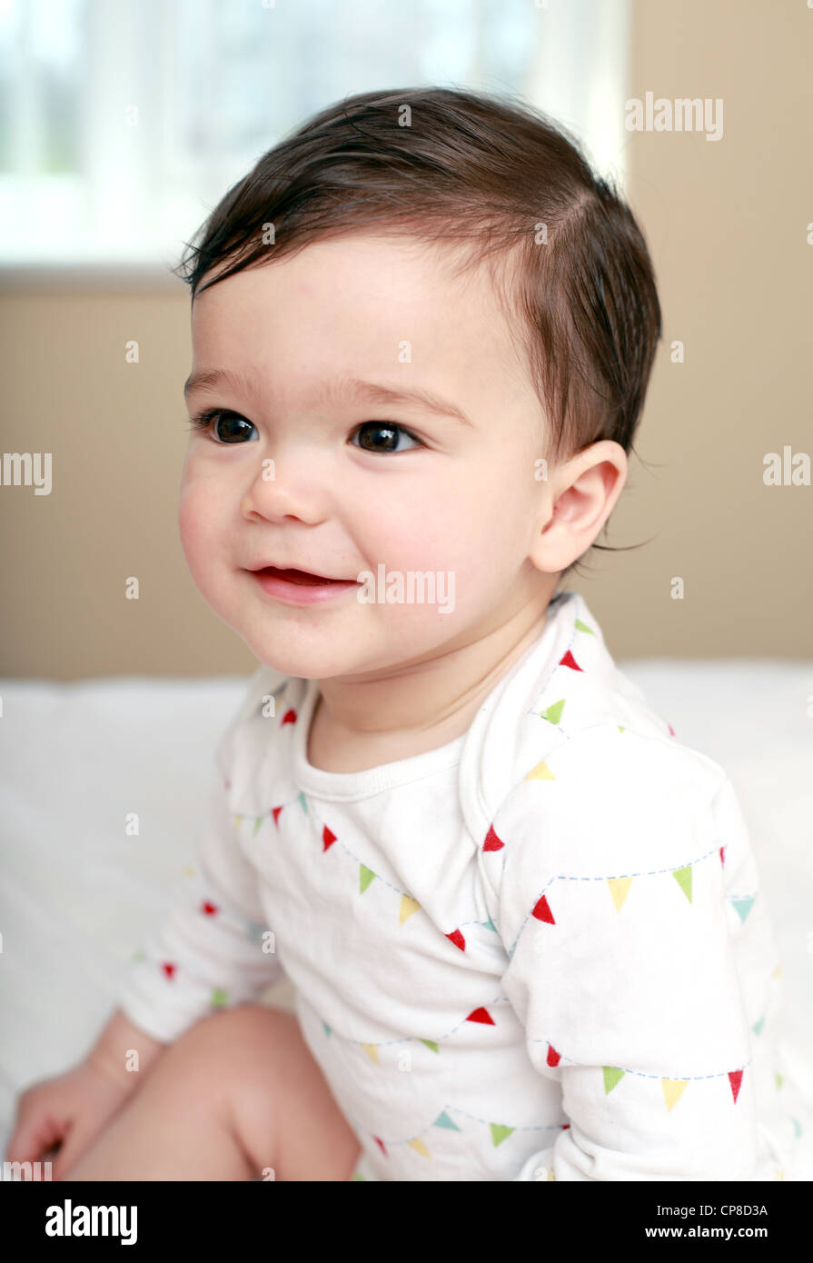 Happy baby sat on bed Stock Photo - Alamy