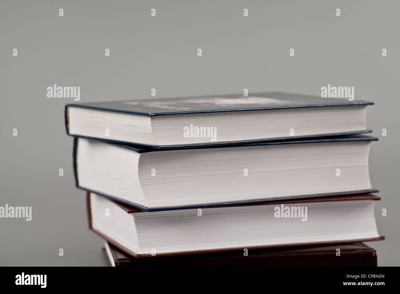 Pile of thick books on gray Stock Photo - Alamy