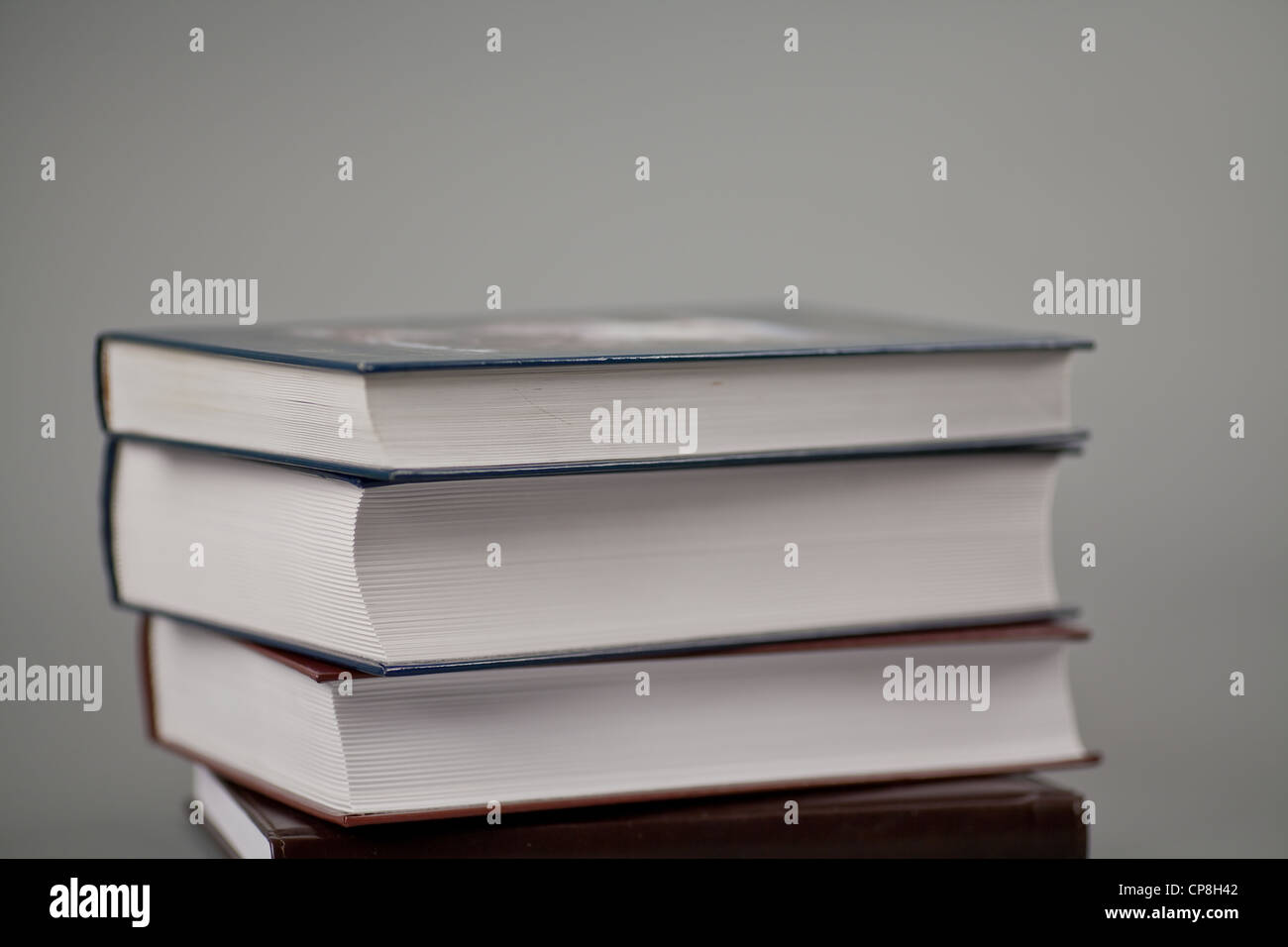 Pile of thick books on gray Stock Photo - Alamy
