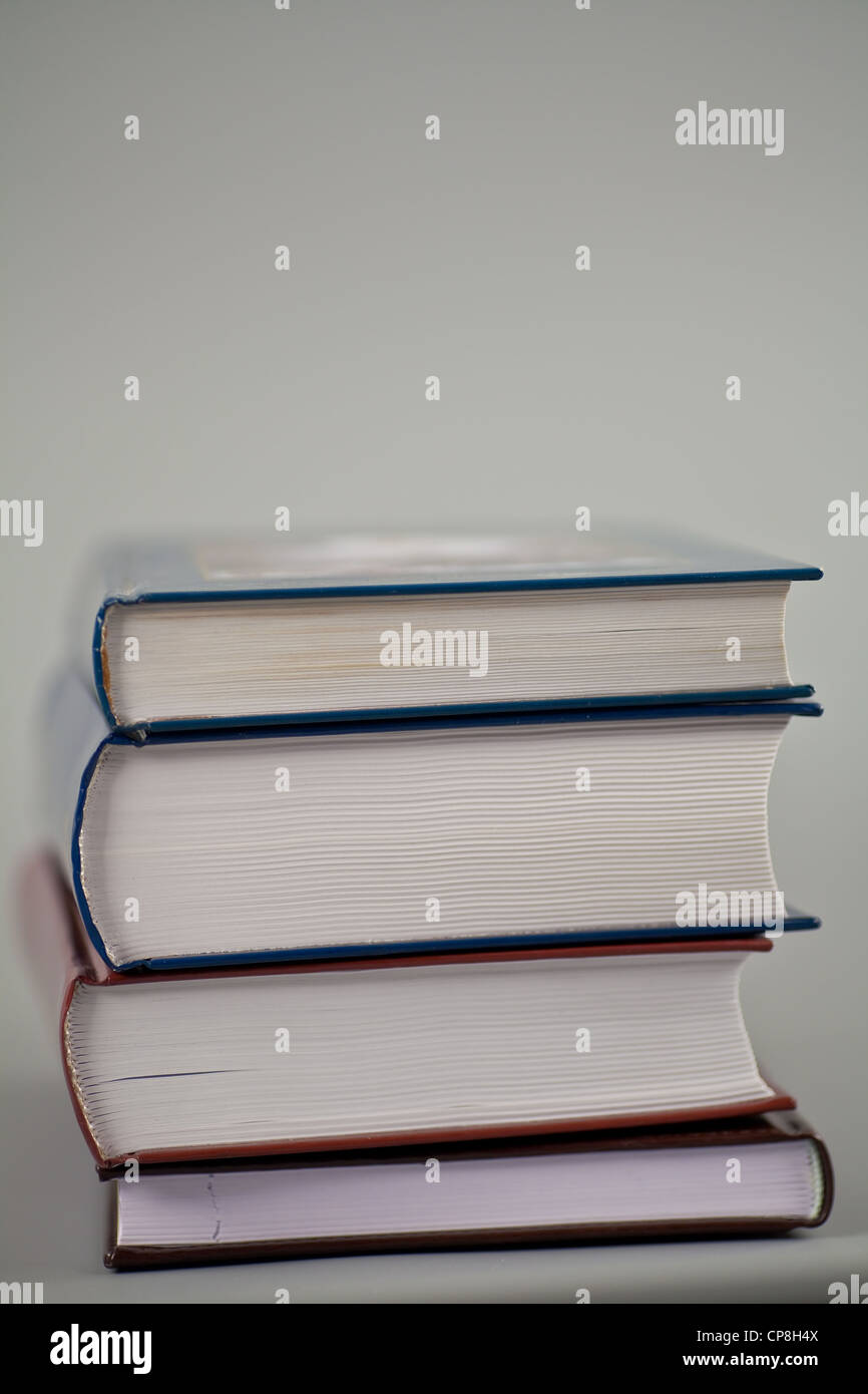 Pile of thick books on gray Stock Photo - Alamy