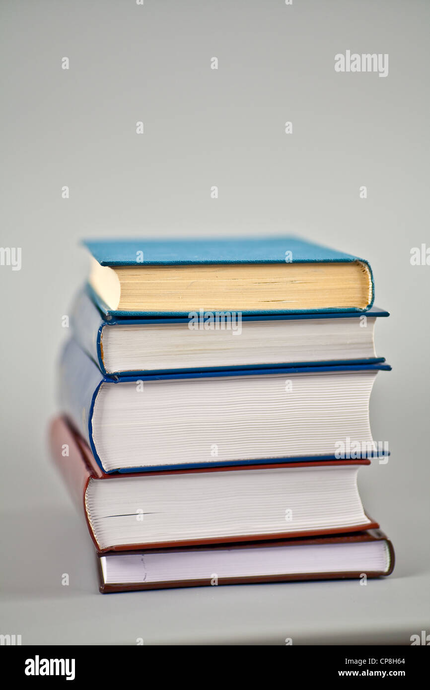 Pile of thick books on gray Stock Photo - Alamy