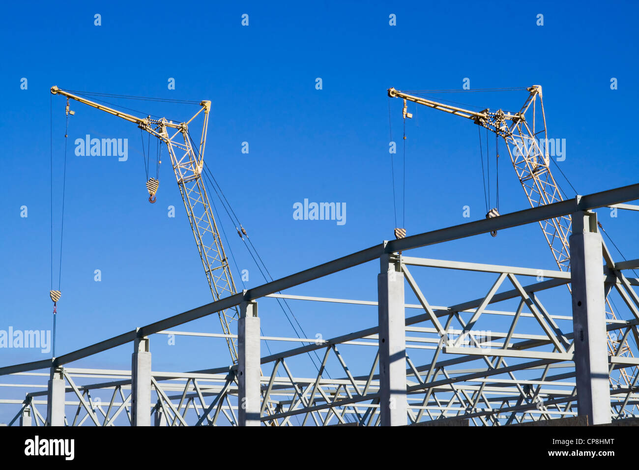 Building, elevating cranes and sunny day Stock Photo - Alamy