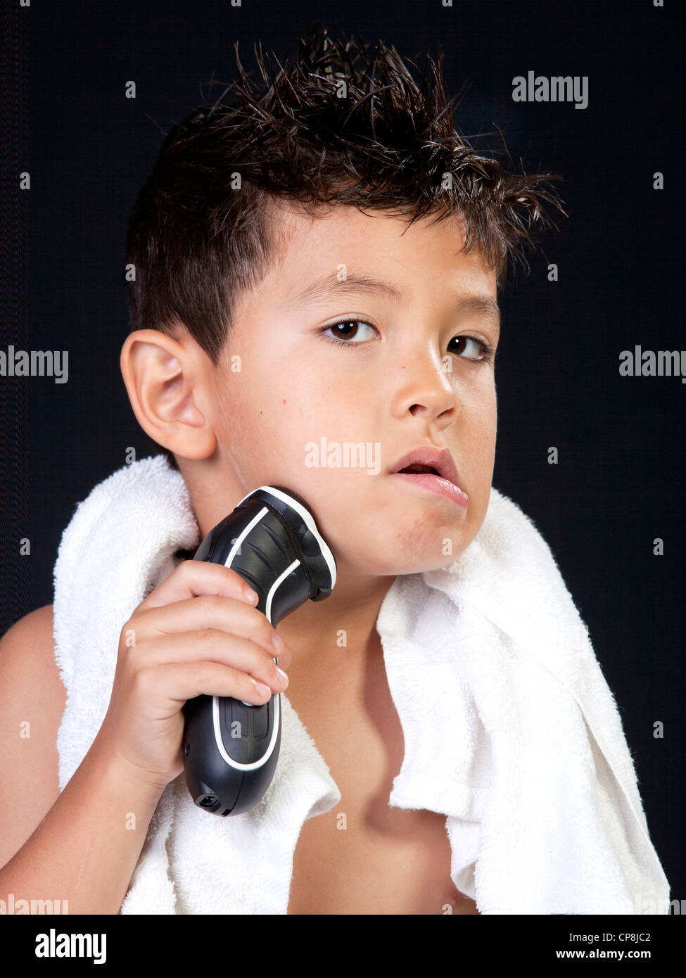A young boy has fun pretending to shave with an electric razor Stock ...