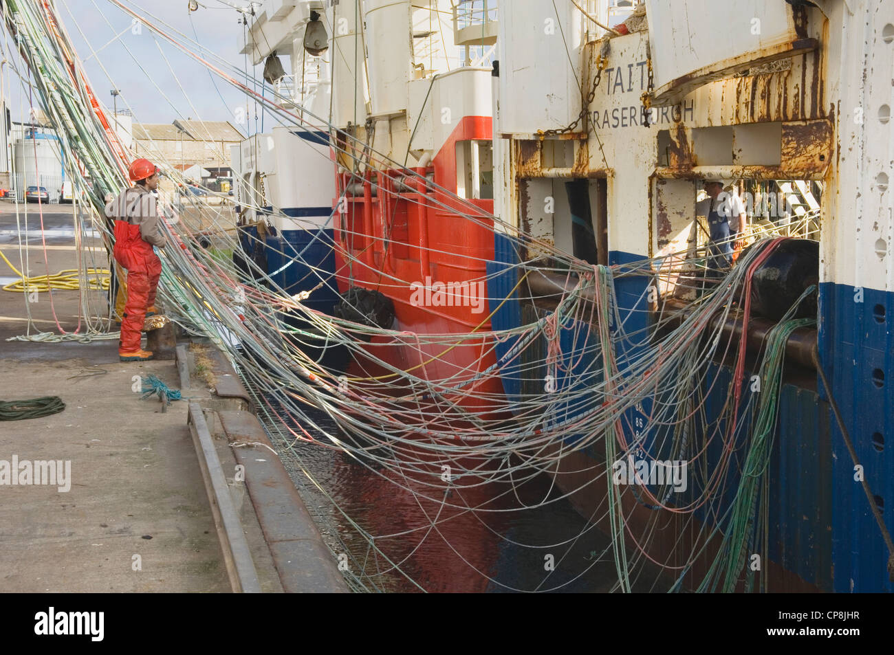 Fishermen working with the nets of a large deep sea trawler in ...