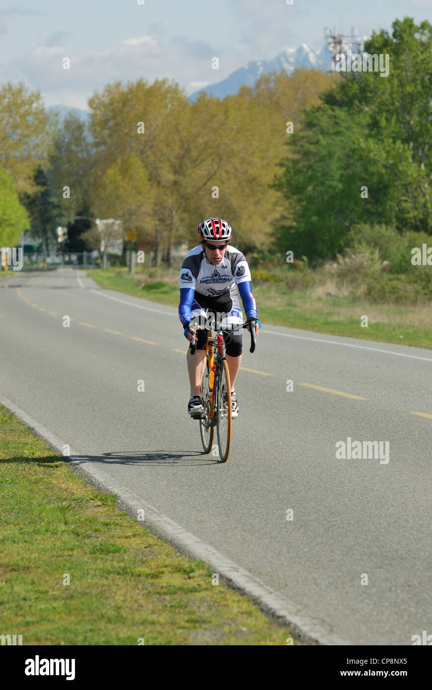 Man riding bicycle on roadway Stock Photo - Alamy