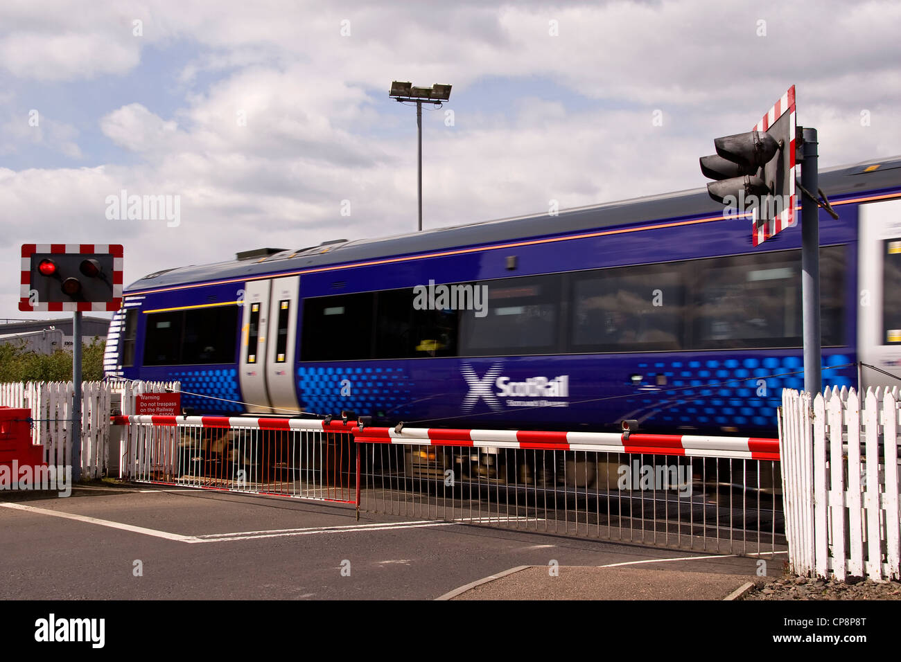 Scotrail commuter train passing a level crossing approaching the ...