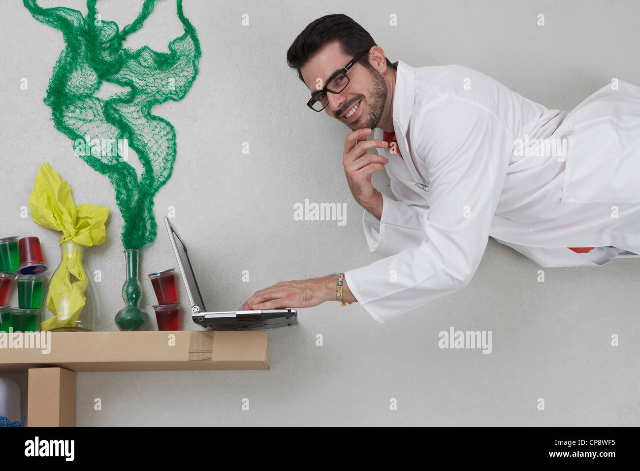 Young man doing experiment and using laptop, portrait Stock Photo - Alamy