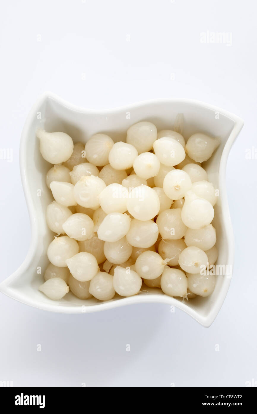 Silverskin onions in bowl on white background Stock Photo - Alamy