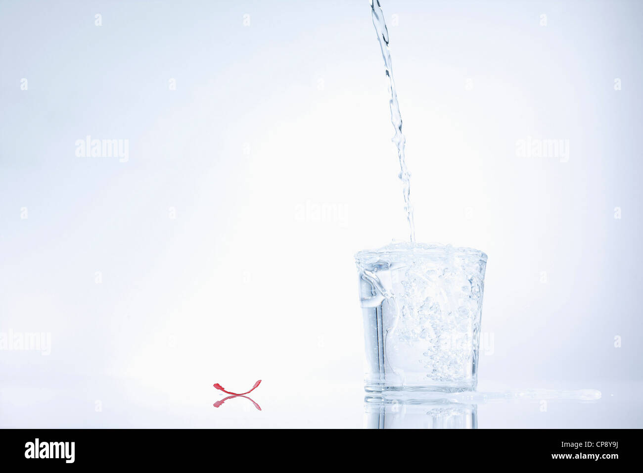 Water pouring into glass and over flowing, close up Stock Photo - Alamy