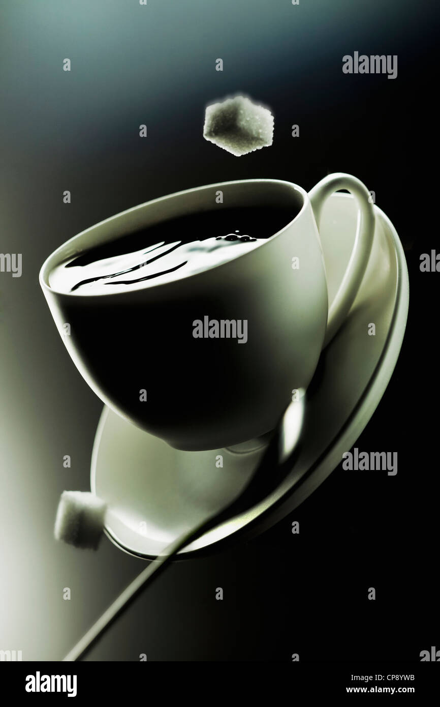 Falling cup of coffee with sugar cubes, close up Stock Photo - Alamy
