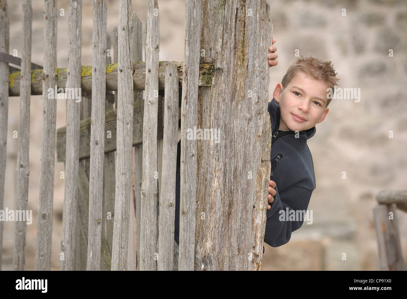Germany, Bavaria, Boy standing behind fence, portrait Stock Photo - Alamy