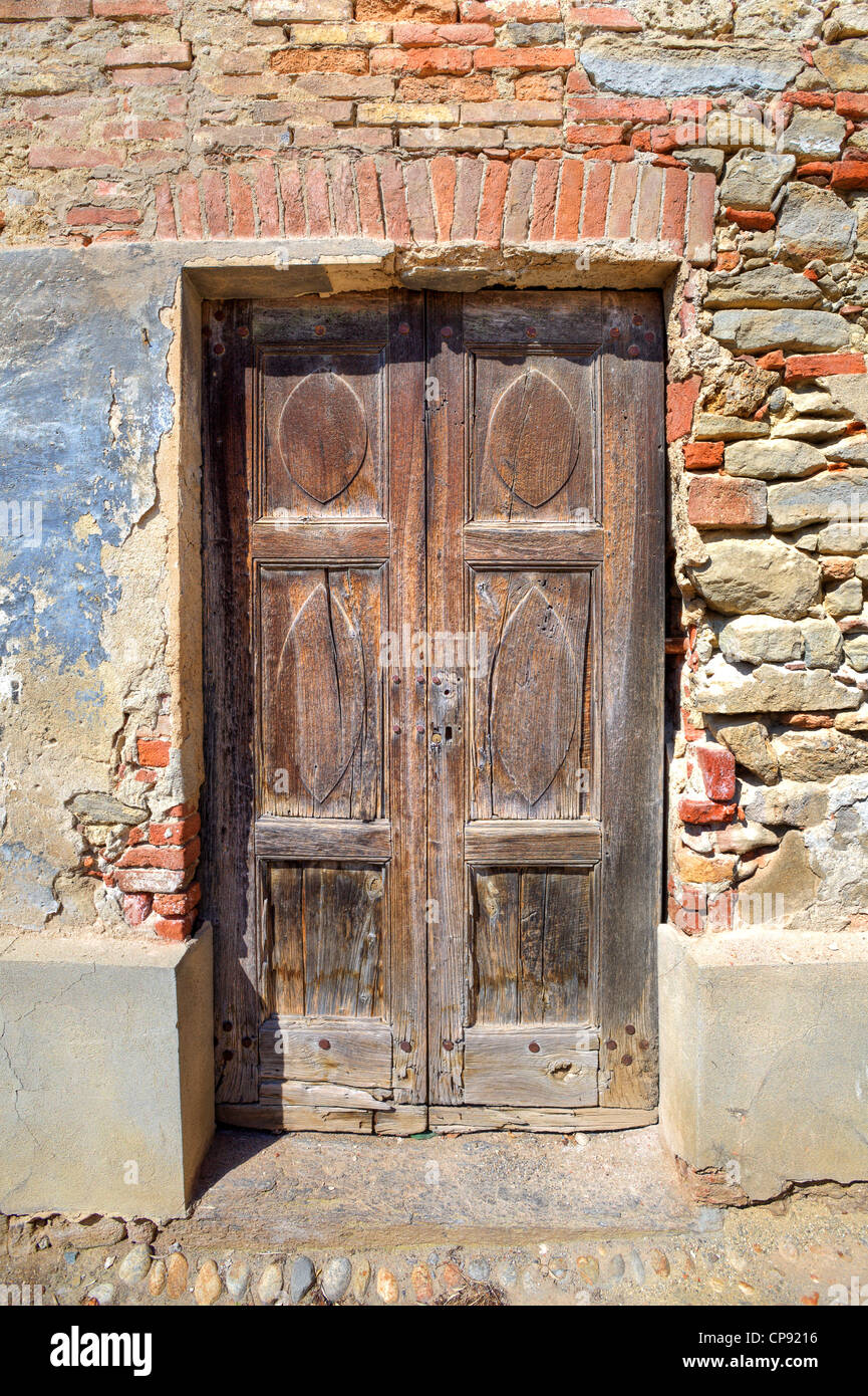 Vertical oriented image of old wooden door in brick house in town of La ...