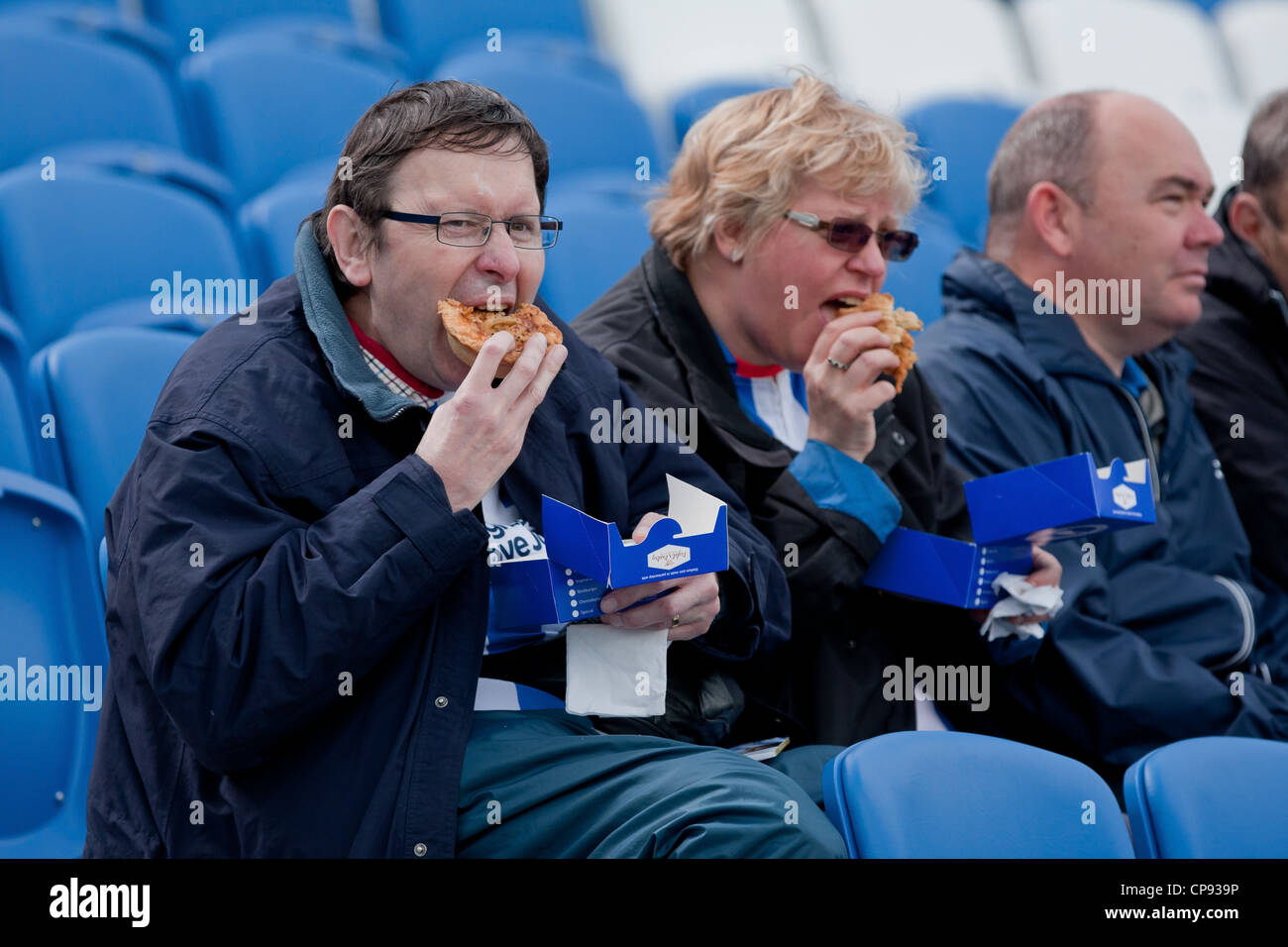 Man eating a pie at a football match in Brighton Stock Photo - Alamy