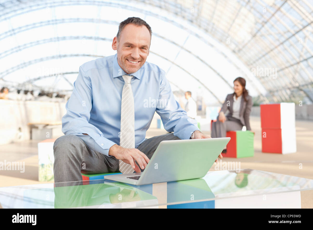 Germany, Leipzig, Businessman using laptop with business people in ...