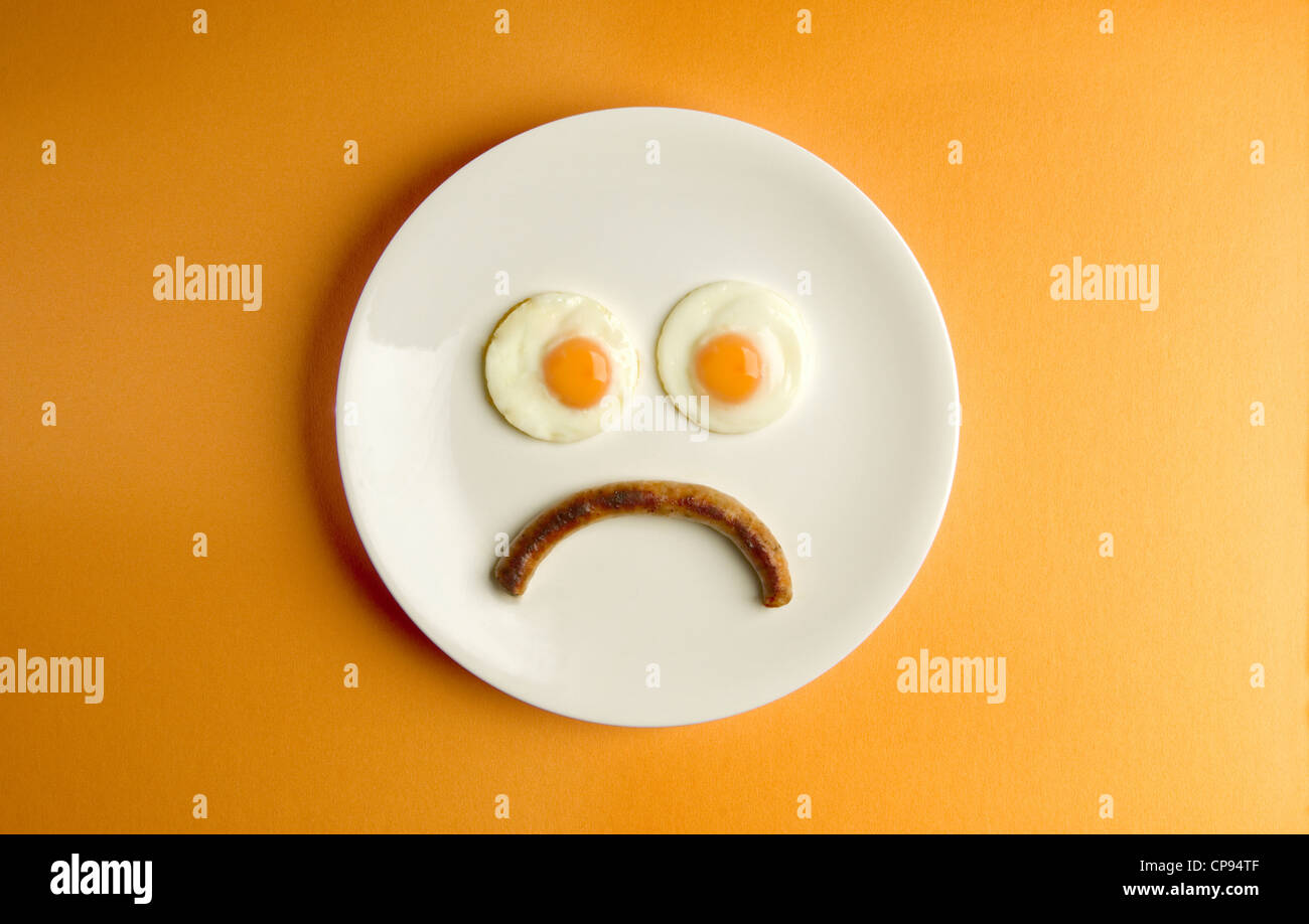 Fried eggs and sausage arranged as a sad face Stock Photo - Alamy