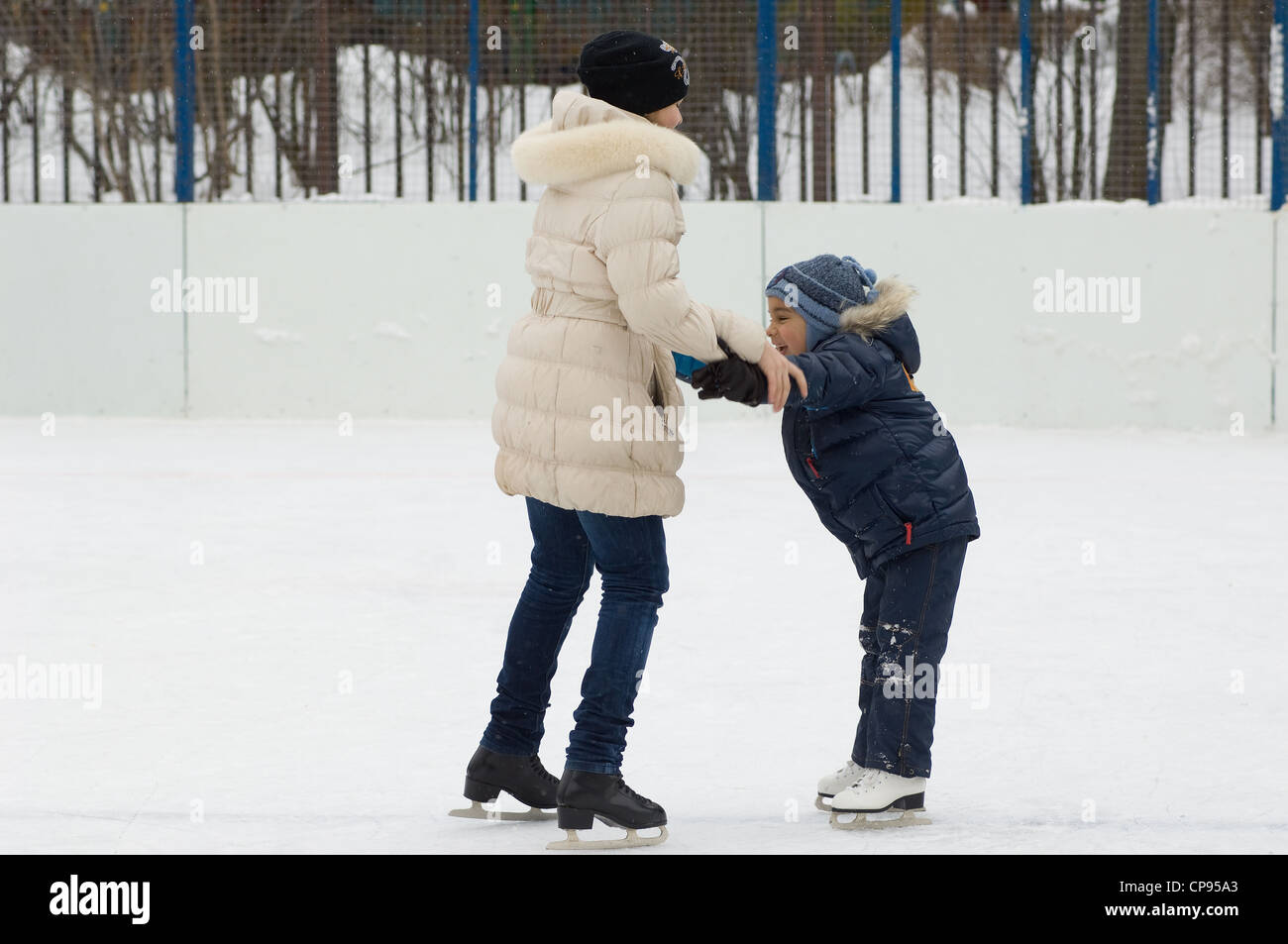 Young girl help a little kid skating. This is the first time he on the ...