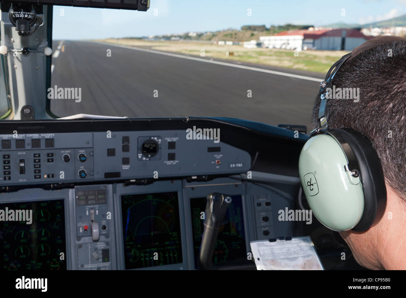Pilot on plane Dash Q400 cabin / cockpit ready to take of Stock Photo ...