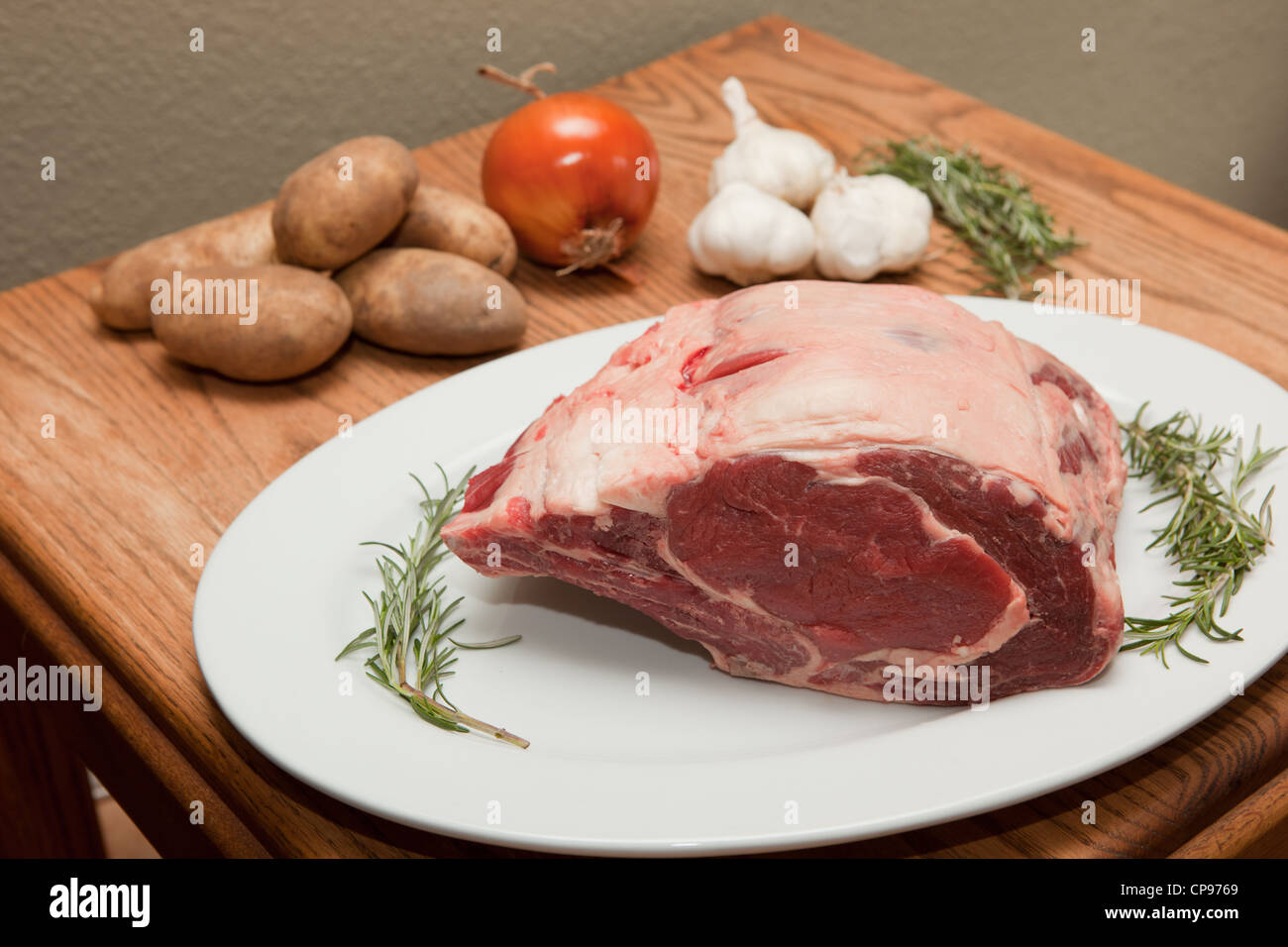 Horizontal view of a large uncooked prime rib roast along with ...