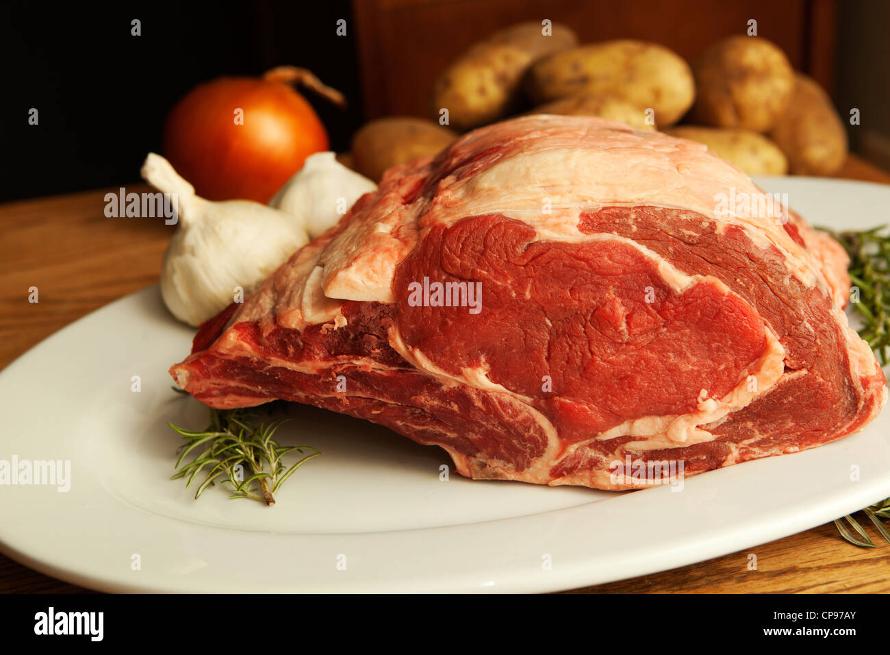 Horizontal view of a large uncooked prime rib roast along with ...