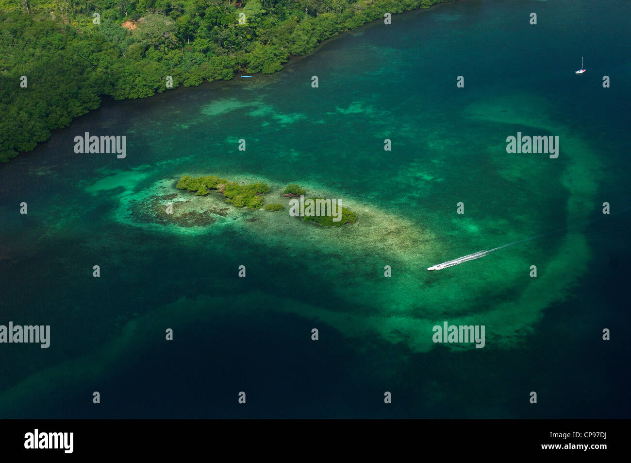 Aerial view of motor boat navigating over reef near the shore. Bocas ...