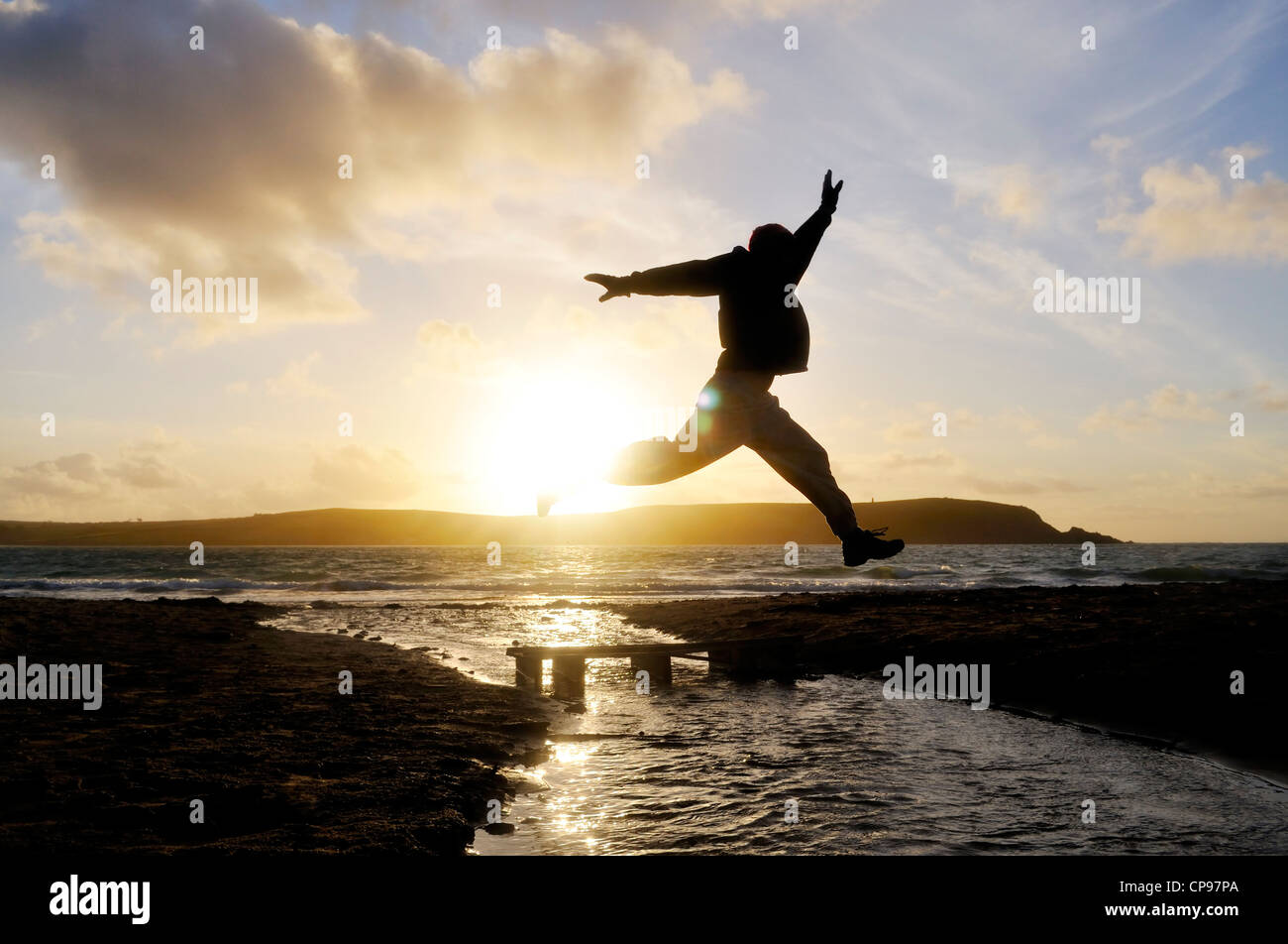 Silhouette of one man jumping over water at the beach Stock Photo - Alamy