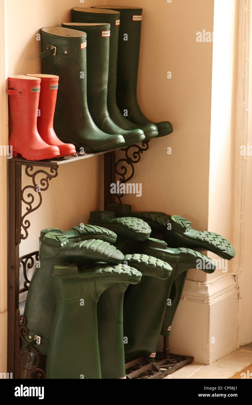 Wellington boots on a storage rack by the front door Stock Photo - Alamy
