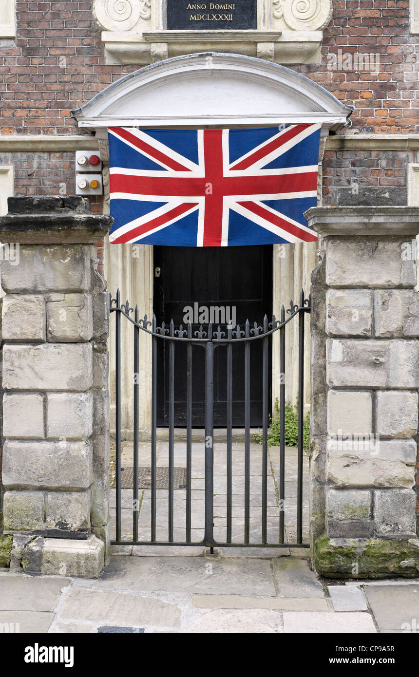 British Union Jack flag hanging above doorway behind iron gate Stock ...
