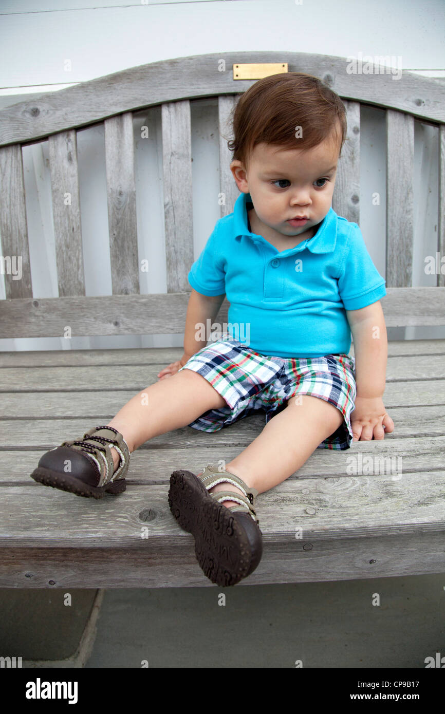 Young Boy Sitting on Bench Stock Photo - Alamy