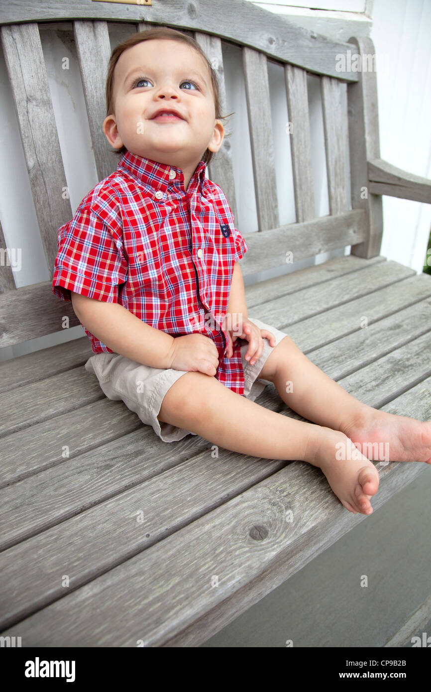 Smiling Young Boy Sitting on Bench Stock Photo - Alamy
