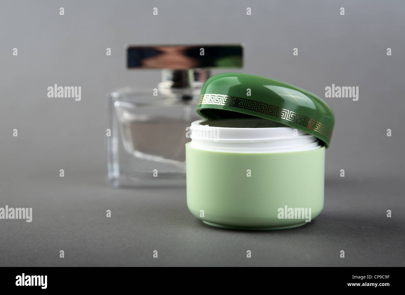 Tube cream and bottle of perfume on a grey background Stock Photo - Alamy