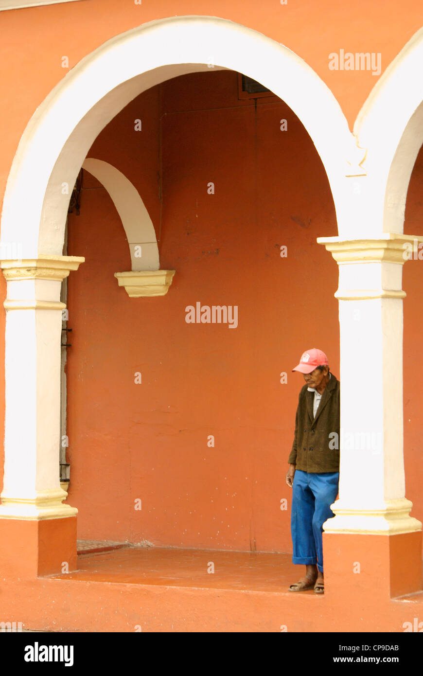 Elderly man standing under an arcade in the Spanish colonial town of ...