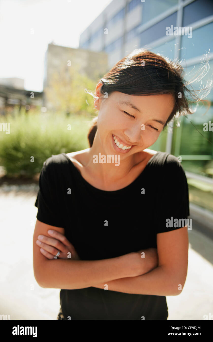 Woman smiling and looking down, outdoors Stock Photo - Alamy